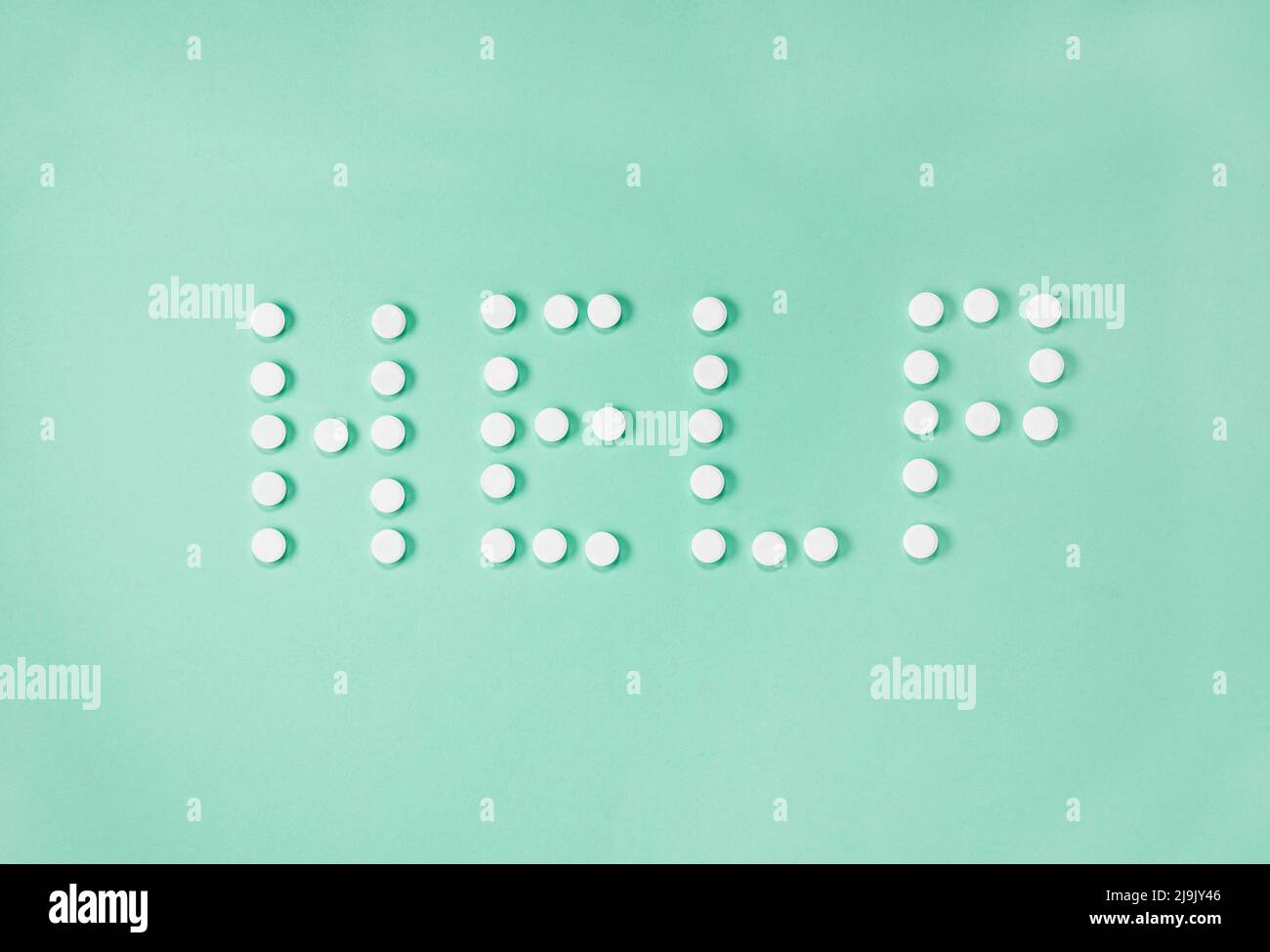 Word help made with white medicine pills on green background ,request ...