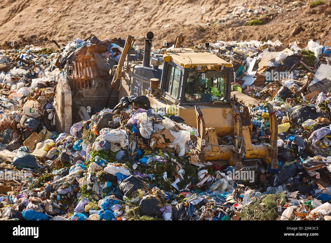 Heavy machinery shredding garbage in an open air landfill. Waste Stock ...
