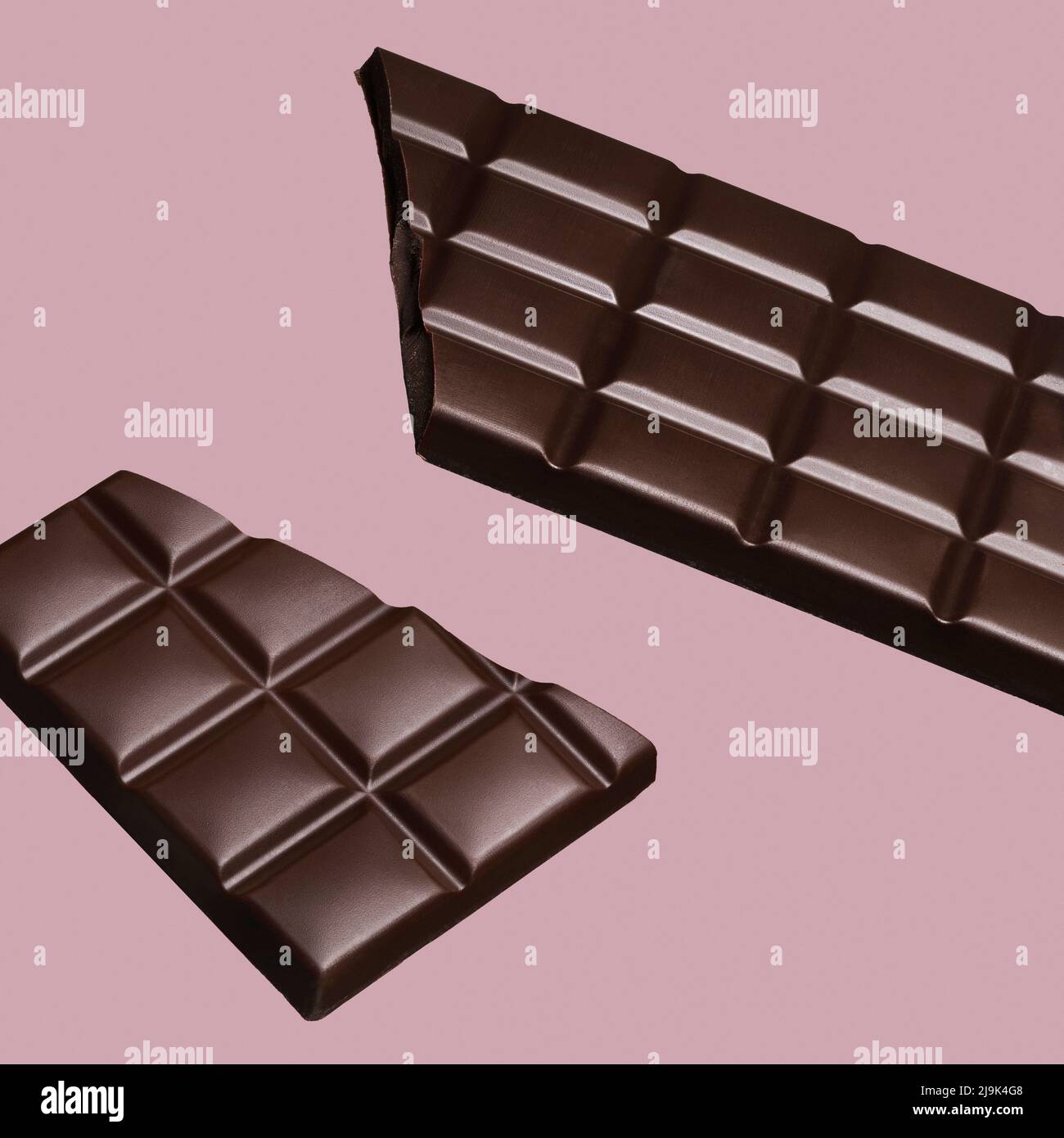 Close up broken chocolate bar on pink background Stock Photo - Alamy