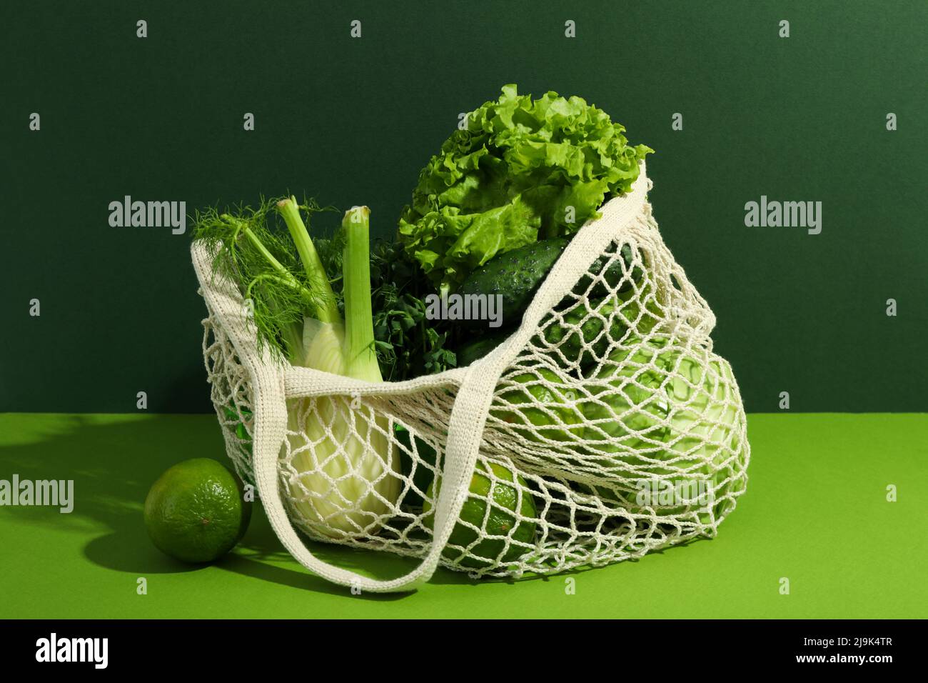 String bag with vegetables and fruits on two tone background Stock ...