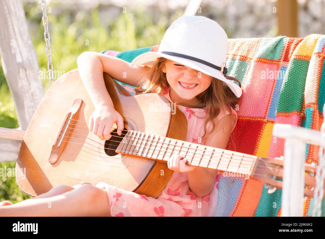 Child musician playing guitar. Stylish little child girl wearing a ...