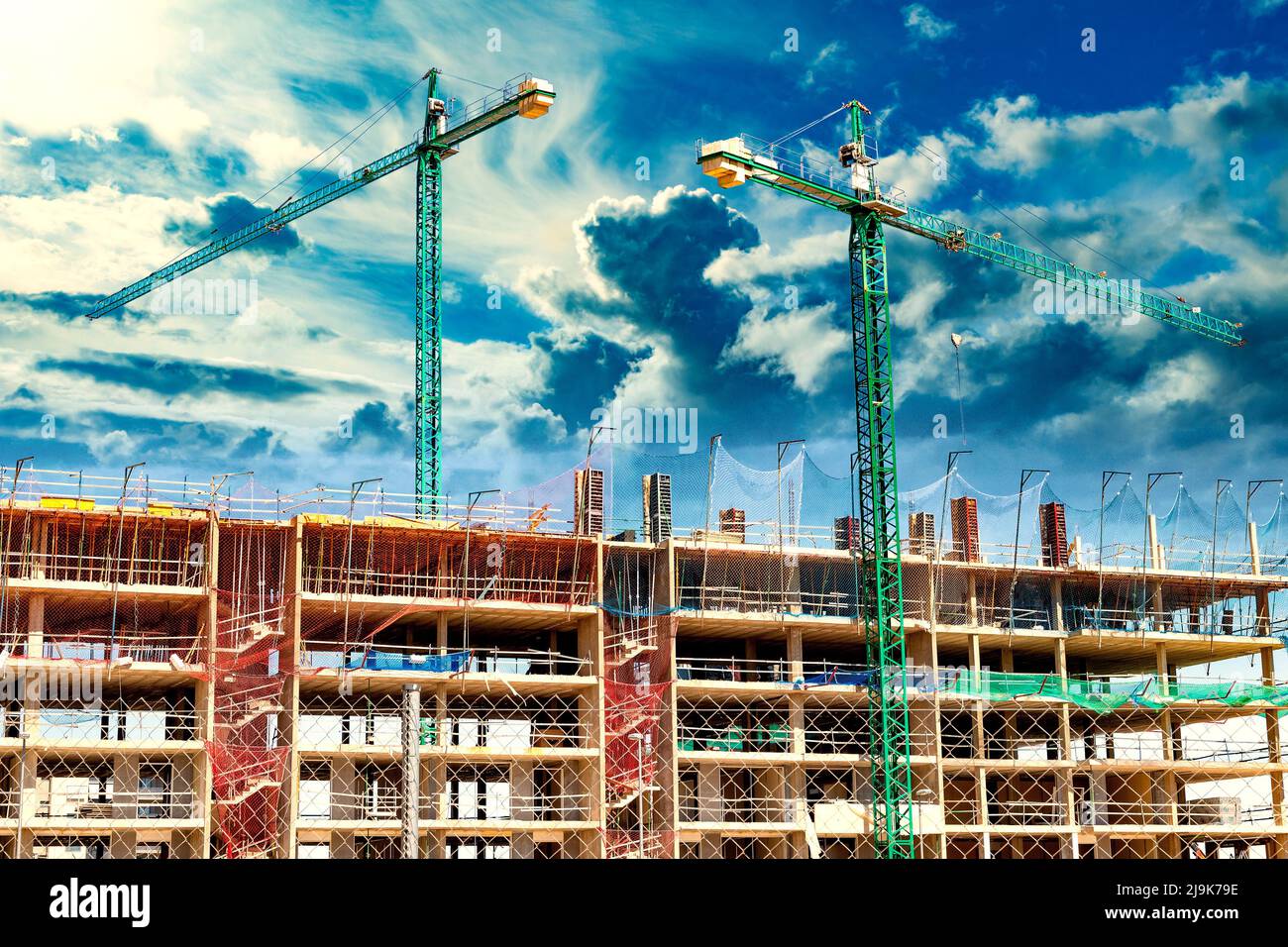 Sunset landscape and construction cranes and buildings. Construct with ...