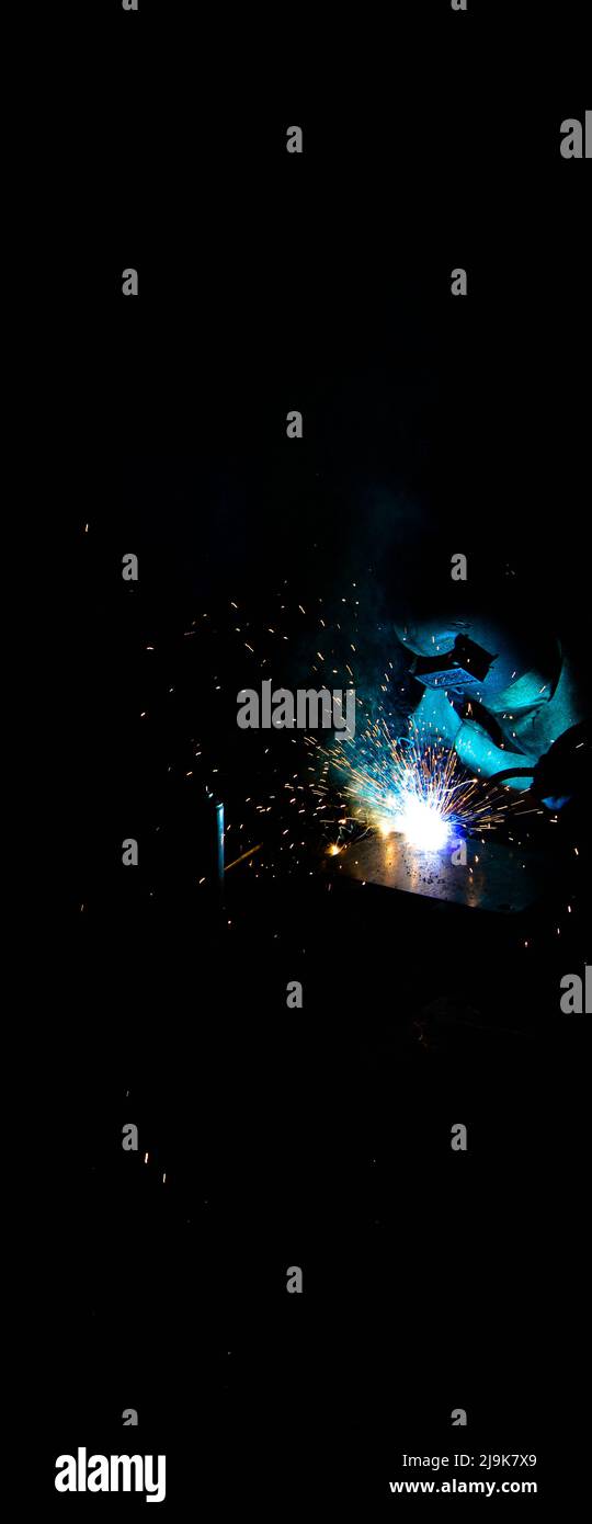 Welder uses torch to make sparks during manufacture of metal equipment ...