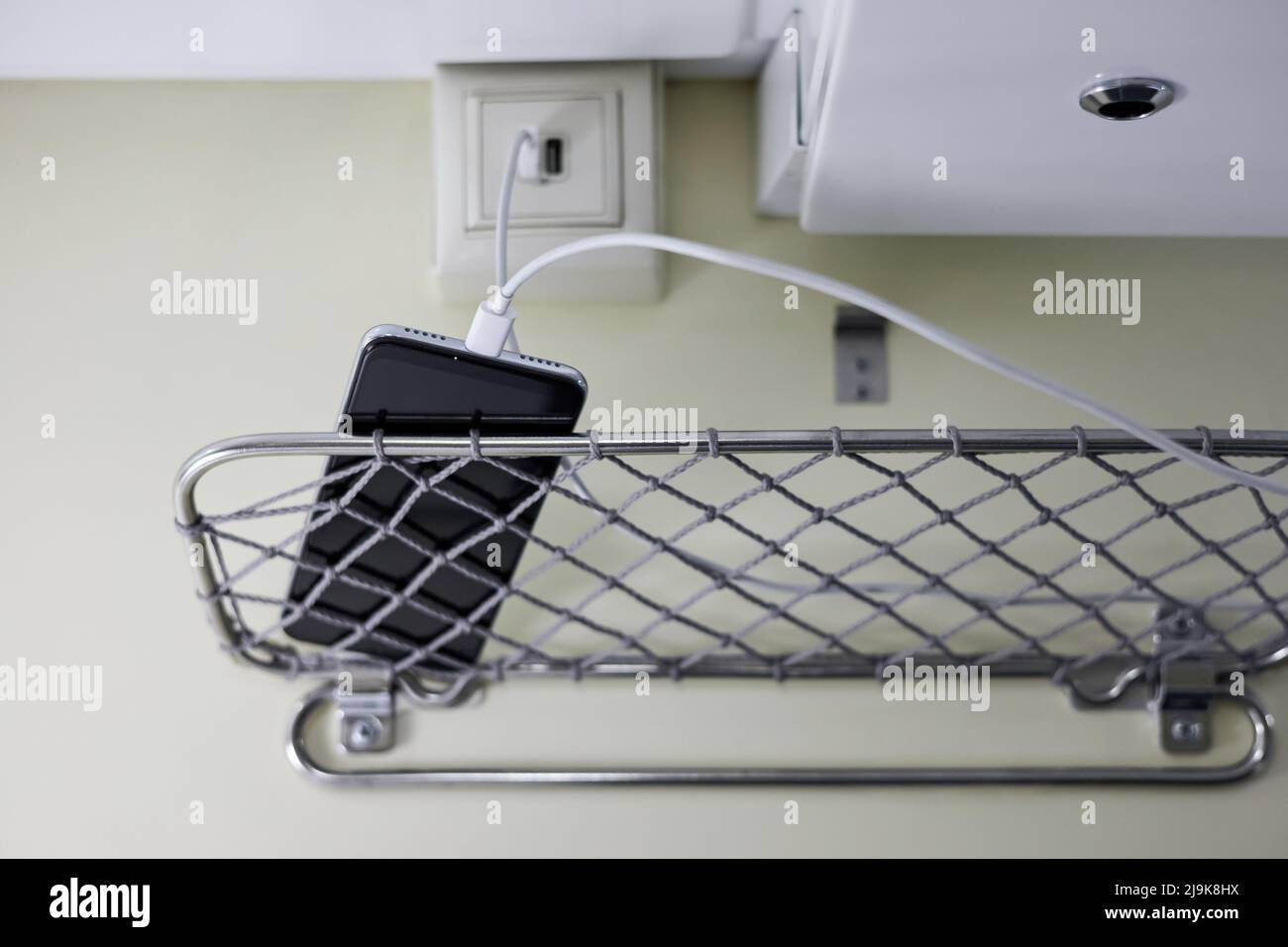 A smartphone is charging in a compartment car of a passenger train ...