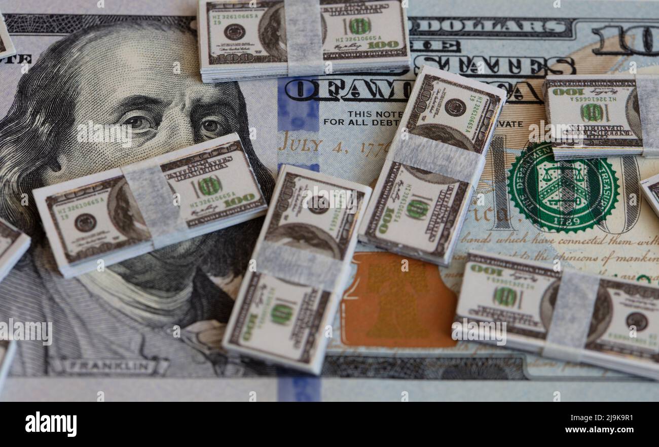 bundles of miniature 100 dollar banknotes on 100 dollar banknote ...