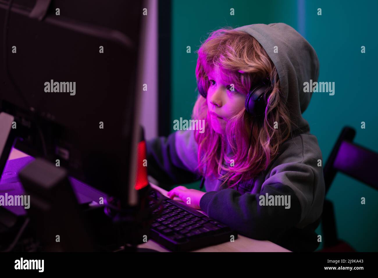 Kid using pc at night. Child with computer in a dark room. Little hacker, young programmer. Kid ...