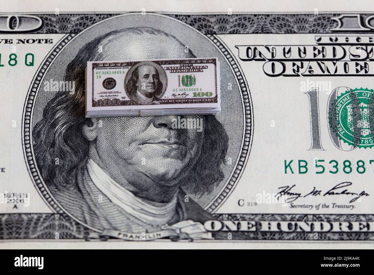 bundles of miniature 100 dollar banknotes on 100 dollar banknote ...