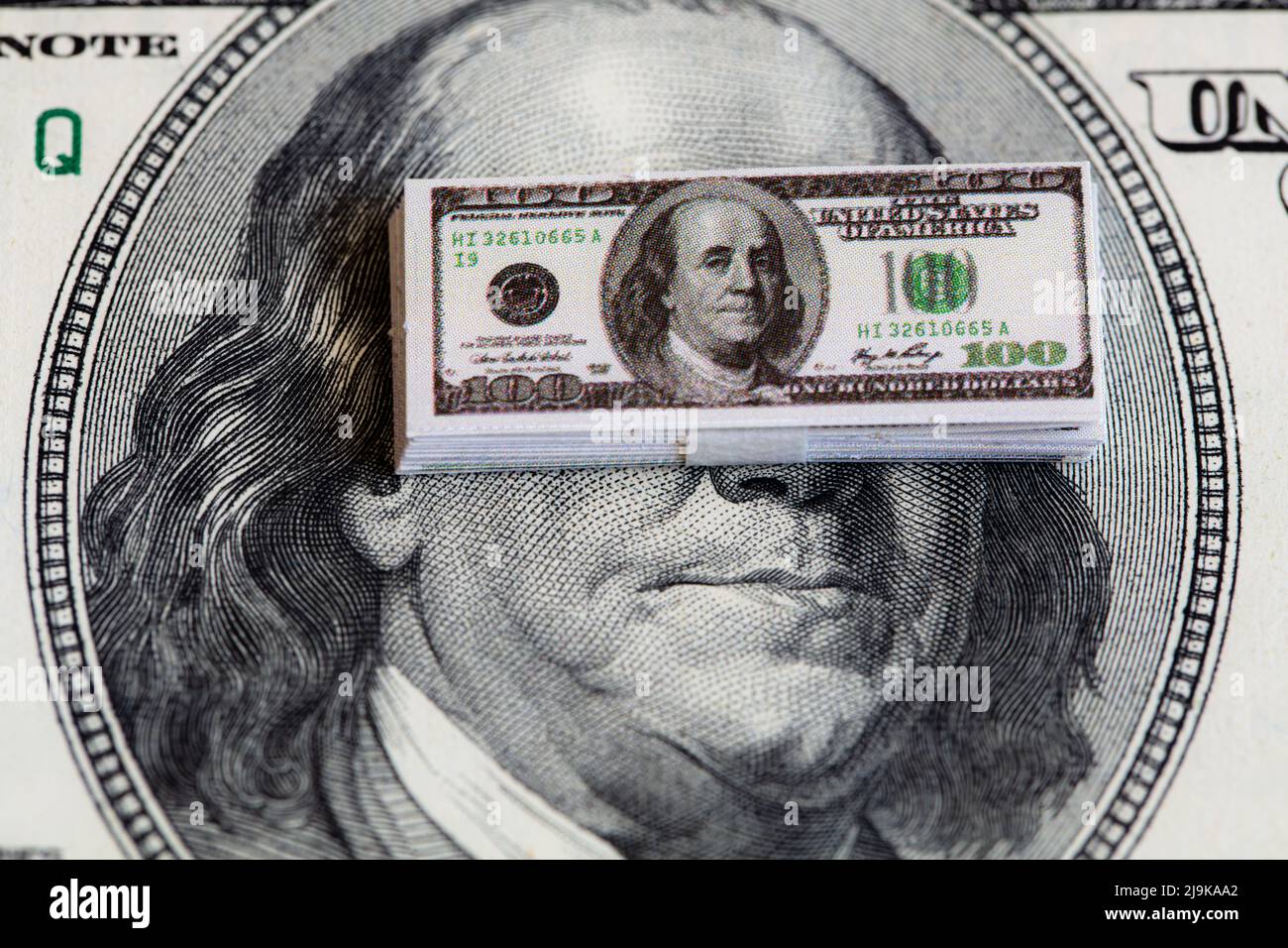 bundles of miniature 100 dollar banknotes on 100 dollar banknote ...