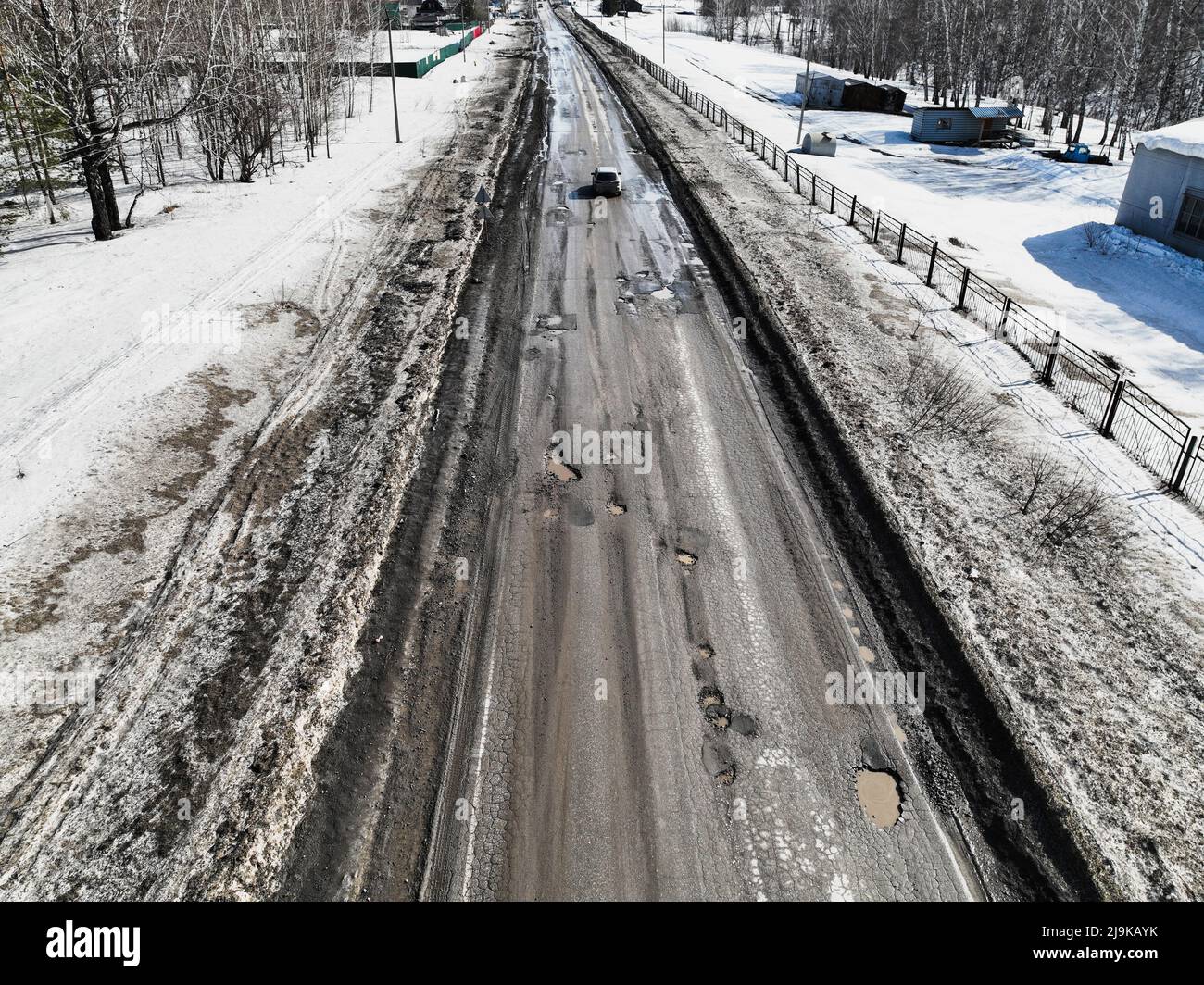 Broken old asphalt road outside the city. Pits and potholes. Aerial ...