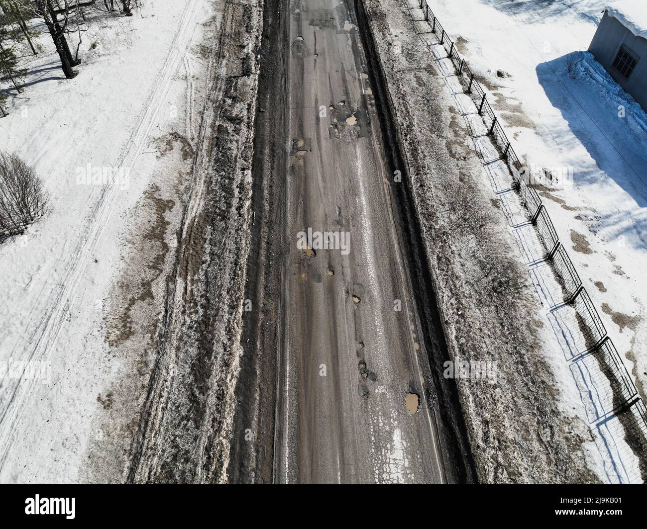 Broken old asphalt road outside the city. Pits and potholes. Aerial ...