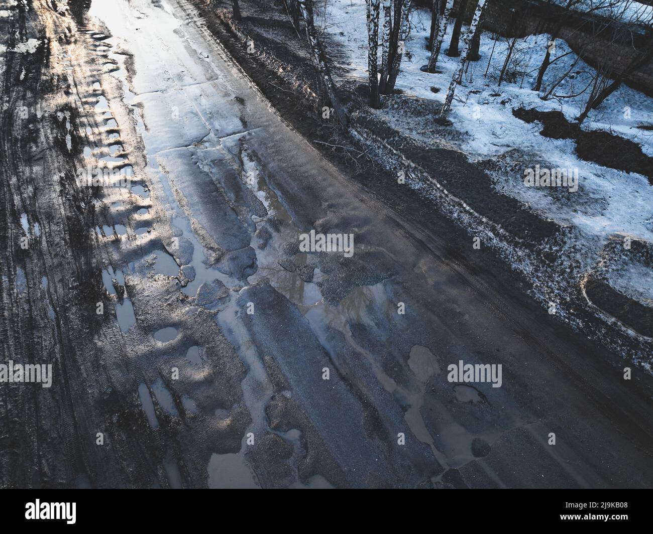 Broken old asphalt road outside the city. Pits and potholes. Aerial ...