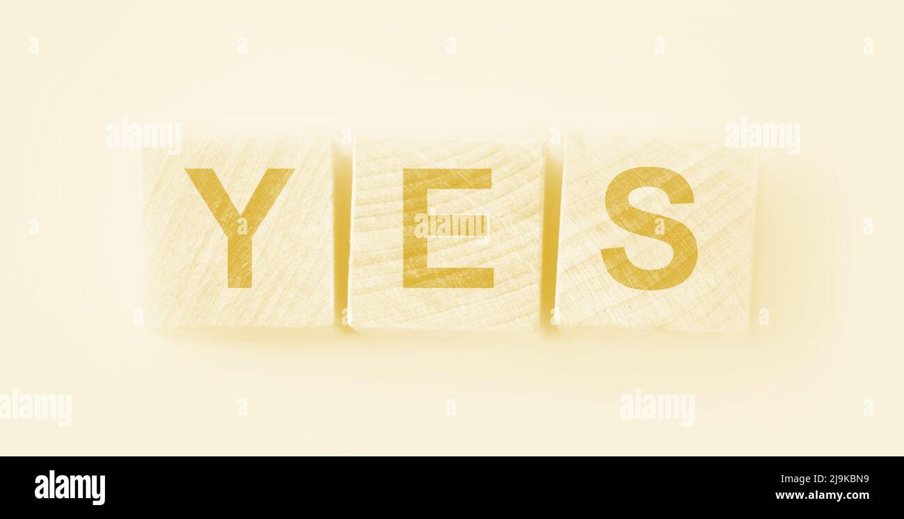 Wooden cubes with word YES on pink table. Positive answer and positive ...