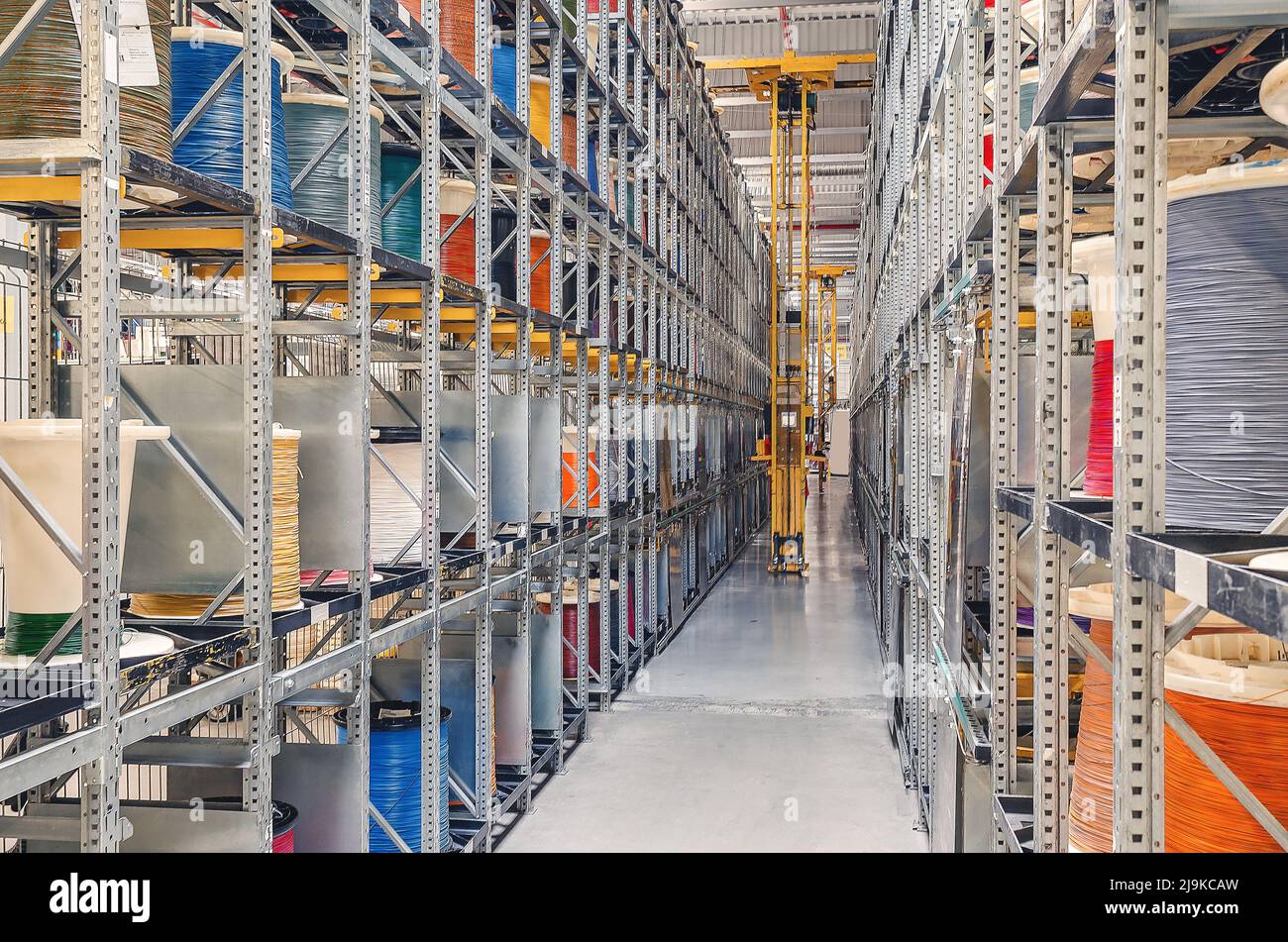 Interior of modern storage warehouse with coils of colored cable on ...