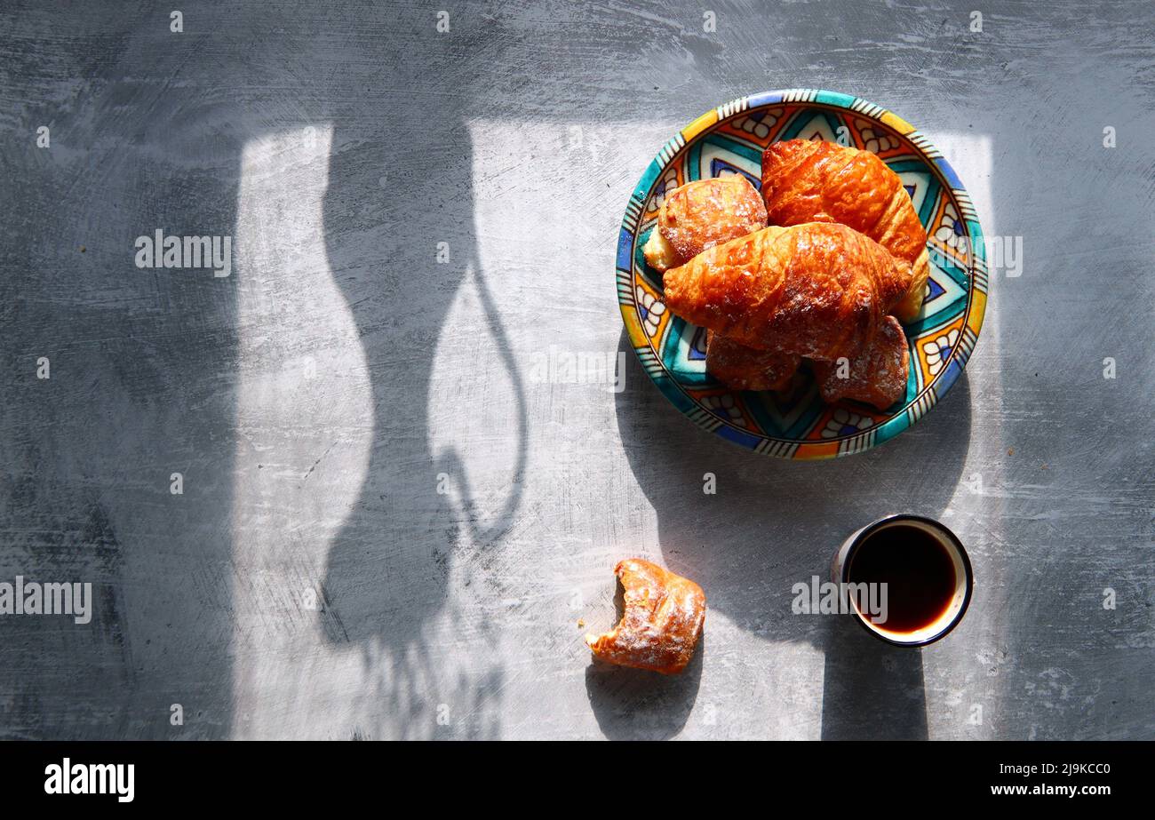 Good morning! Black coffee and croissants on a table. Sunny picture ...
