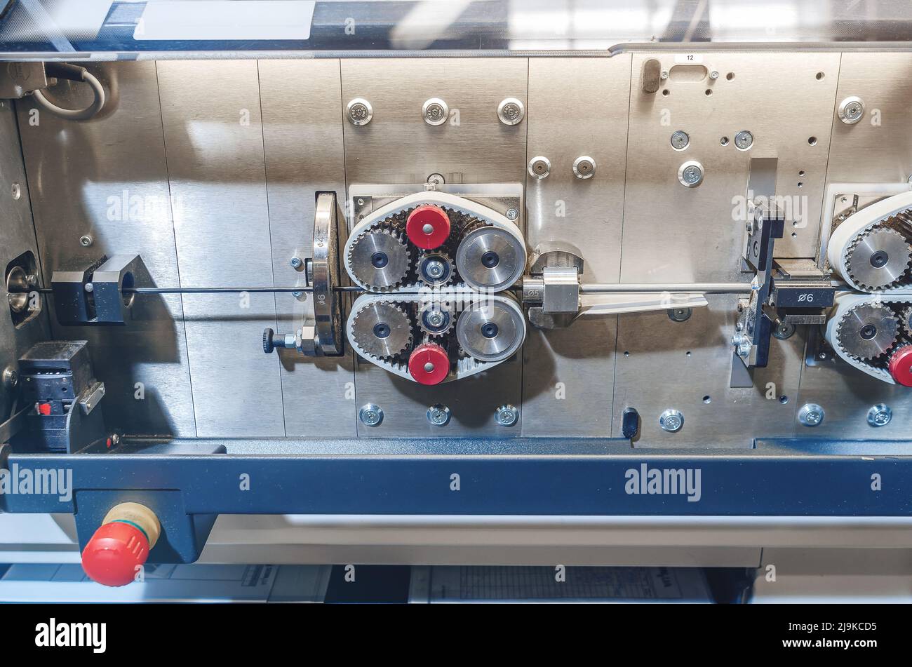 Pulling wire through gears on machine. Part of industrial equipment at ...