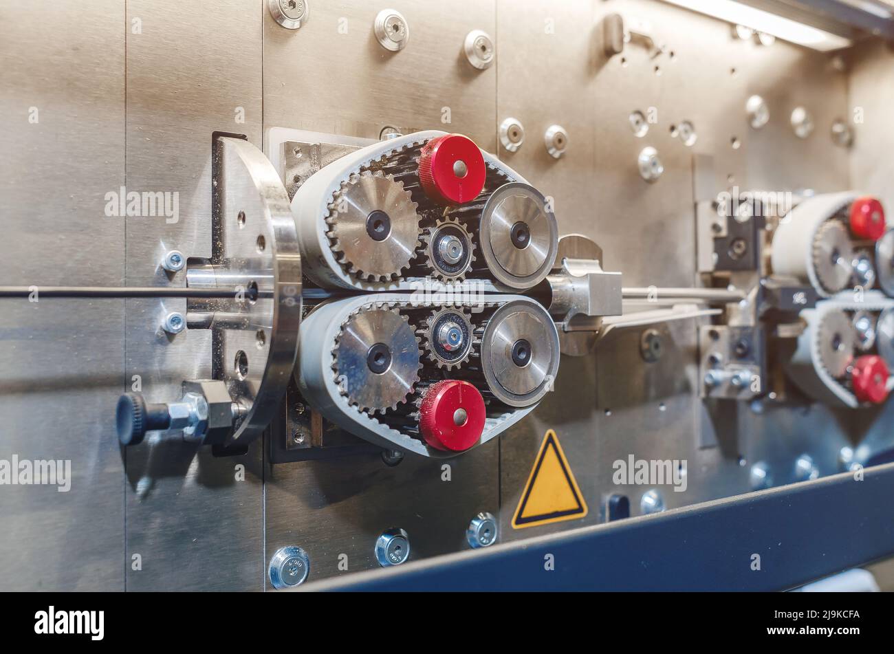 Pulling wire through gears on machine. Part of industrial equipment at ...