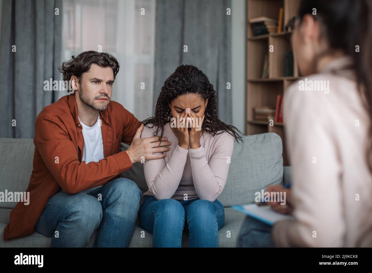 Sad millennial european man comforting crying african american woman on ...