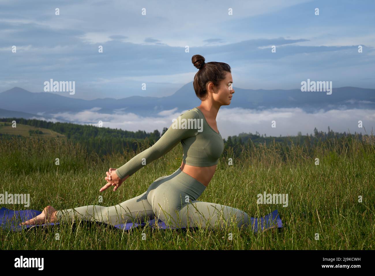 Attractive young woman in sport clothes stretching body during morning ...