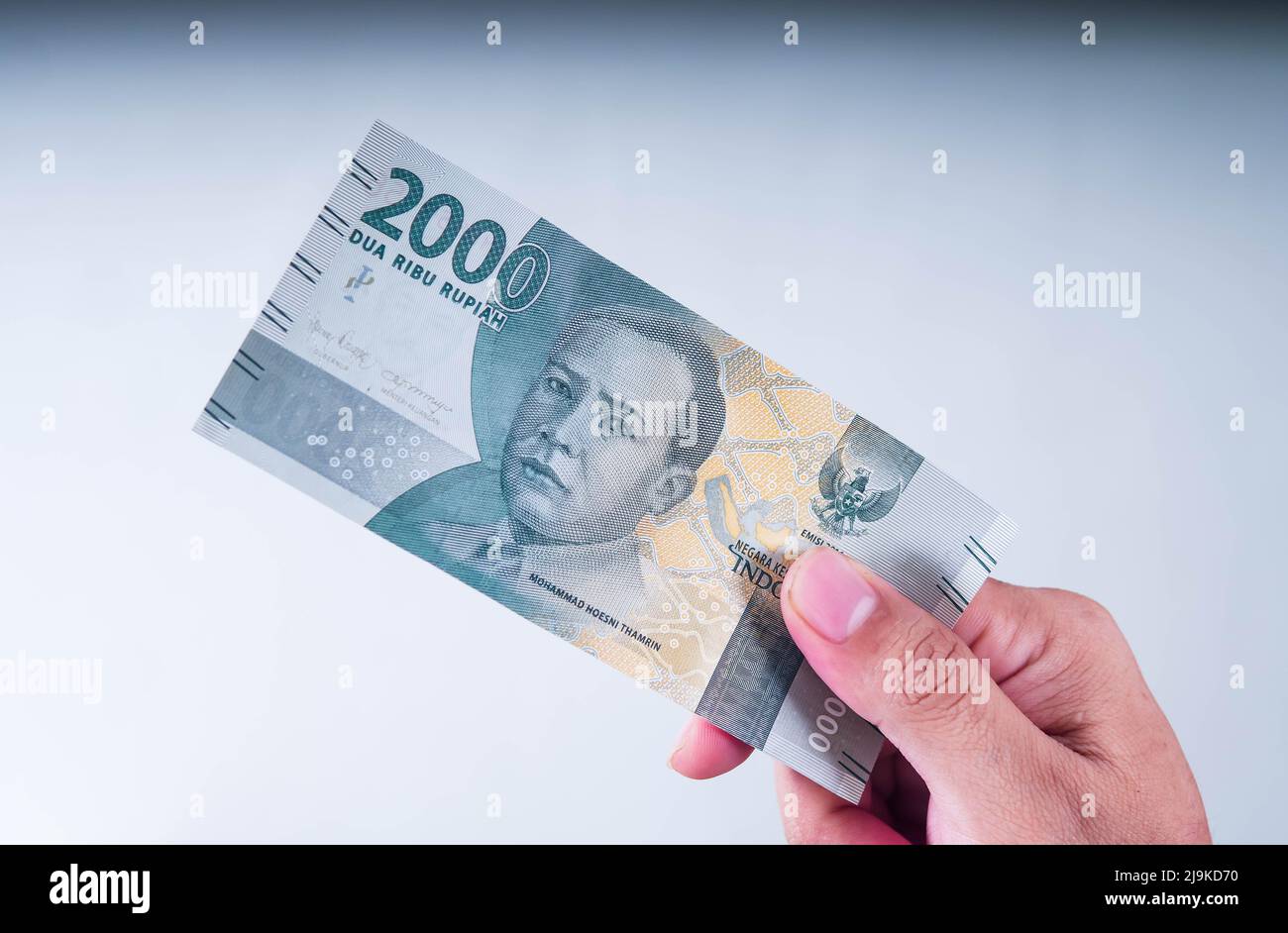 Hand holding indonesian rupiah hi-res stock photography and images - Alamy