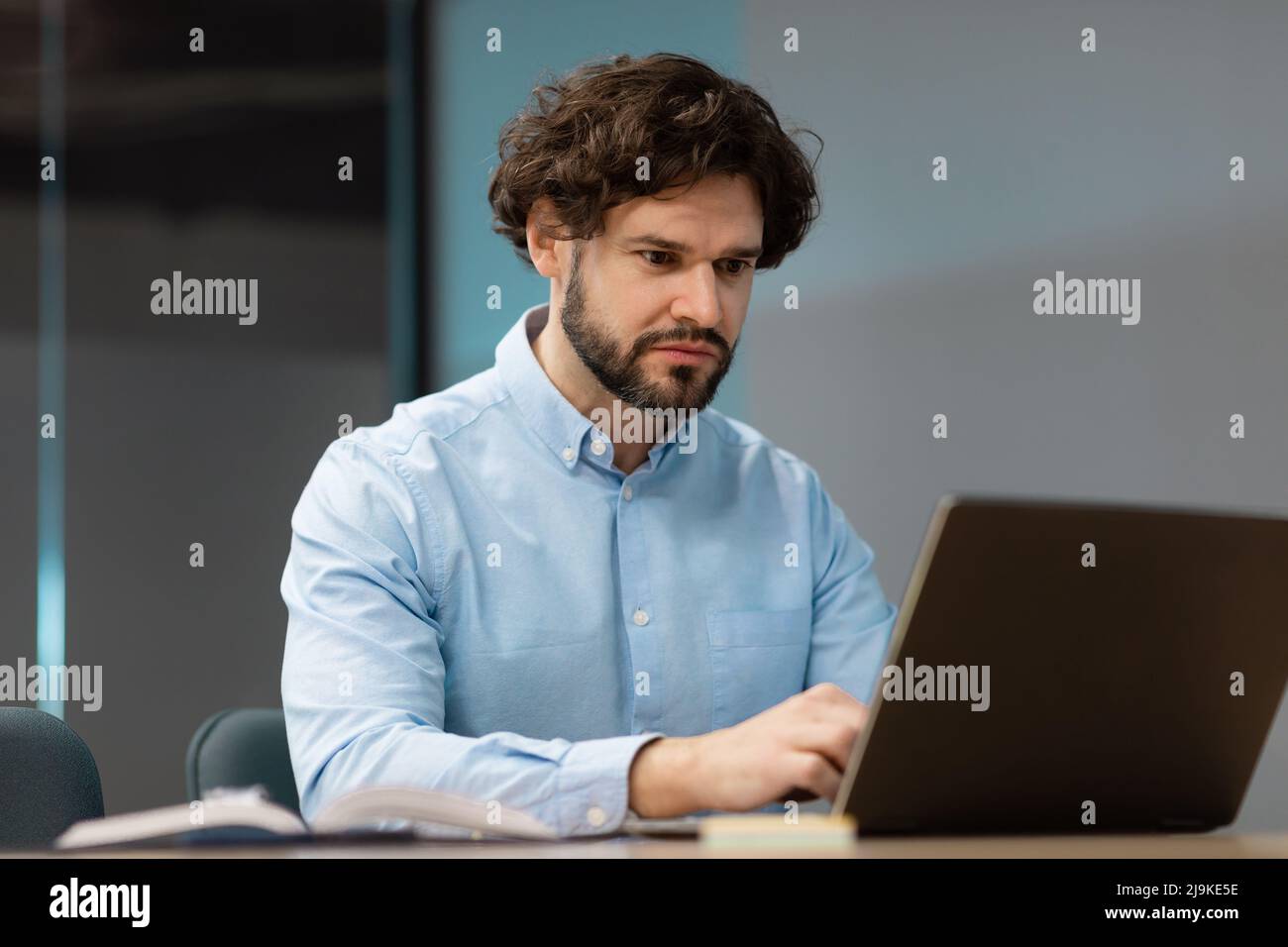 Business man using laptop sitting on chair in office Stock Photo - Alamy