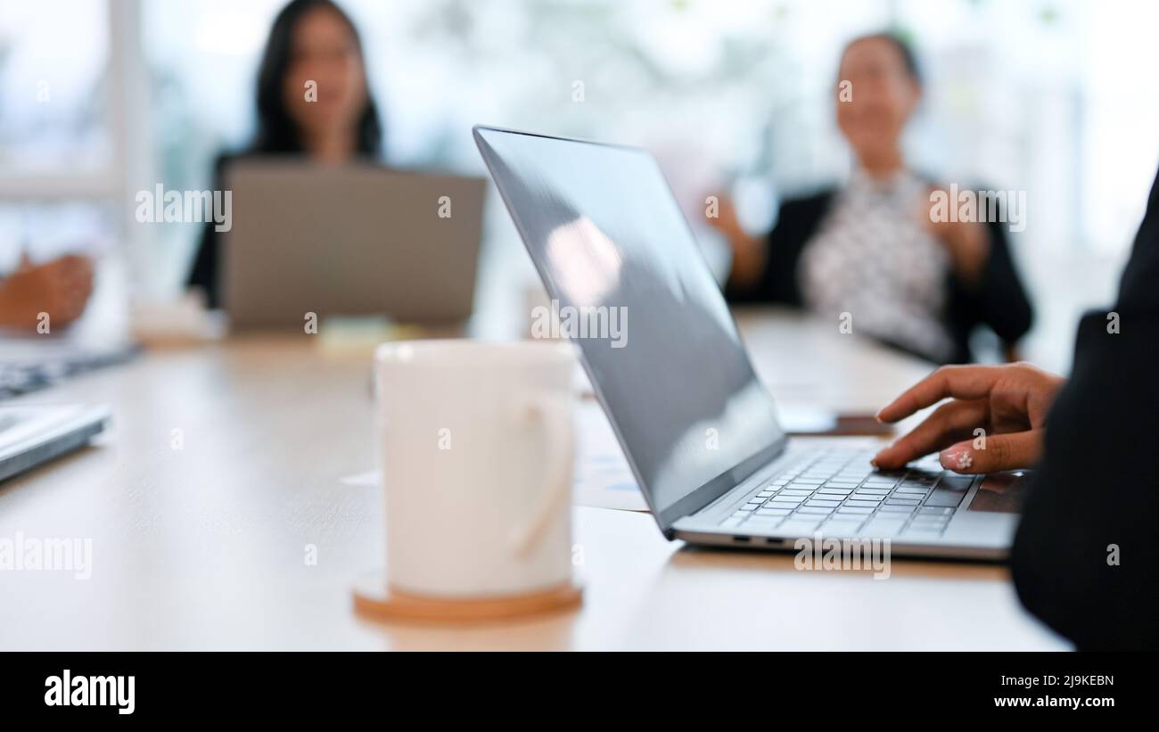 Close-up, During a meeting with board members, a businesswoman uses a ...