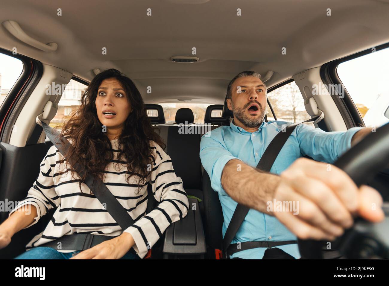 Scared couple driving car, front portrait, windshield view Stock Photo ...