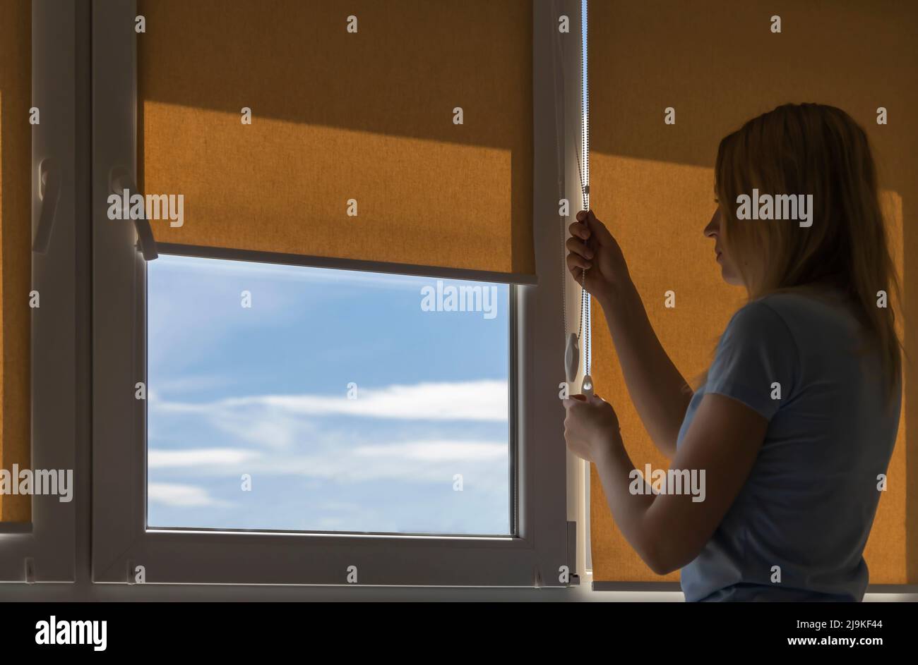 Silhouette of a woman opening the blinds on a sunny morning Stock Photo ...