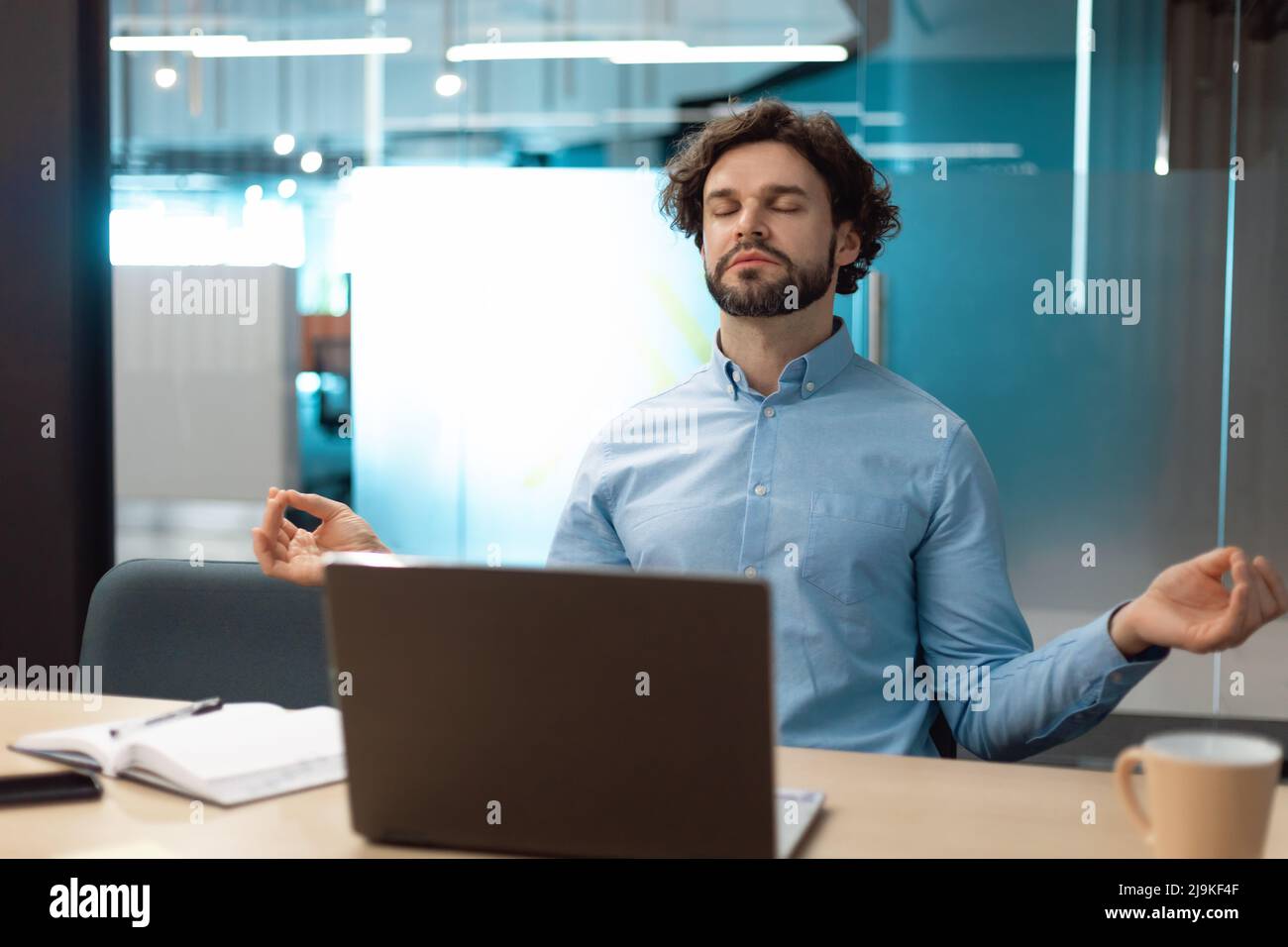 Business man meditating with closed eyes in front of laptop Stock Photo ...