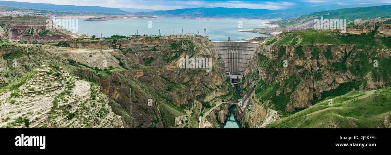 mountain landscape with an arched hydroelectric dam and a reservoir in ...