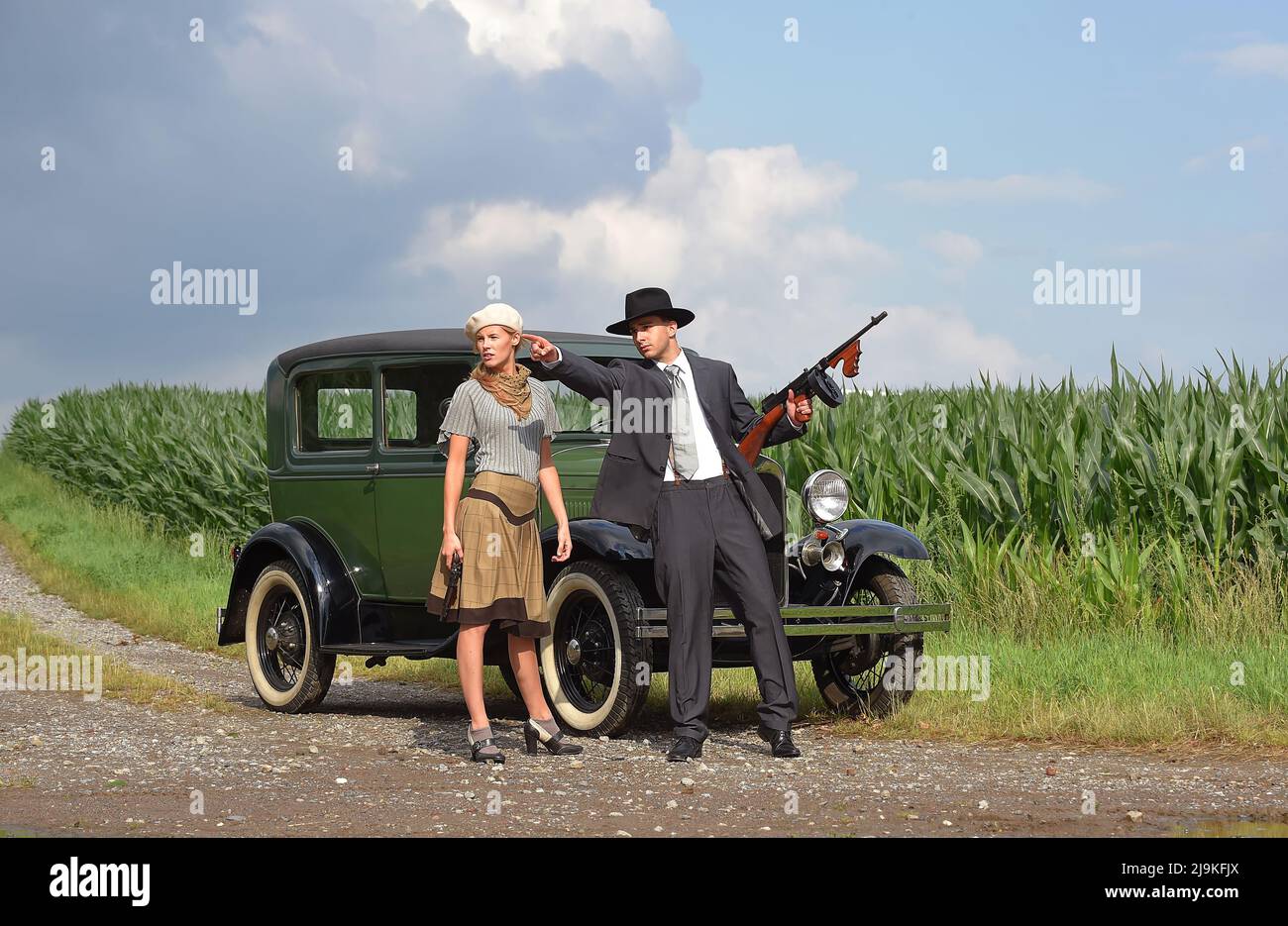 A young couple get dressed up in 1930 style clothing. They each carry a ...