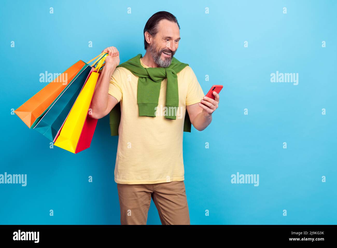 Portrait of funny excited person use telephone read hold packages ...