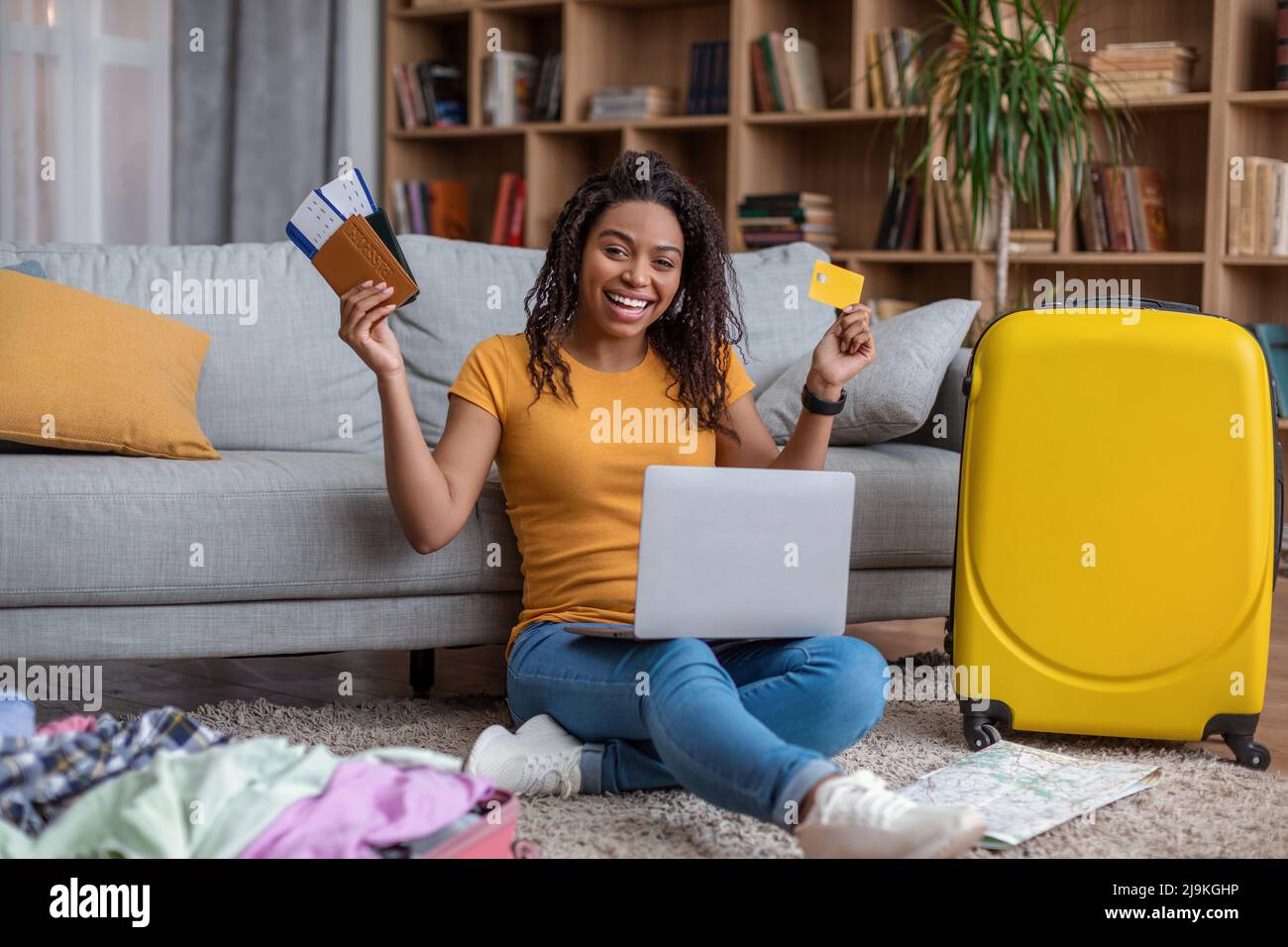 Online tickets booking. Excited black woman with passport and airplane ...