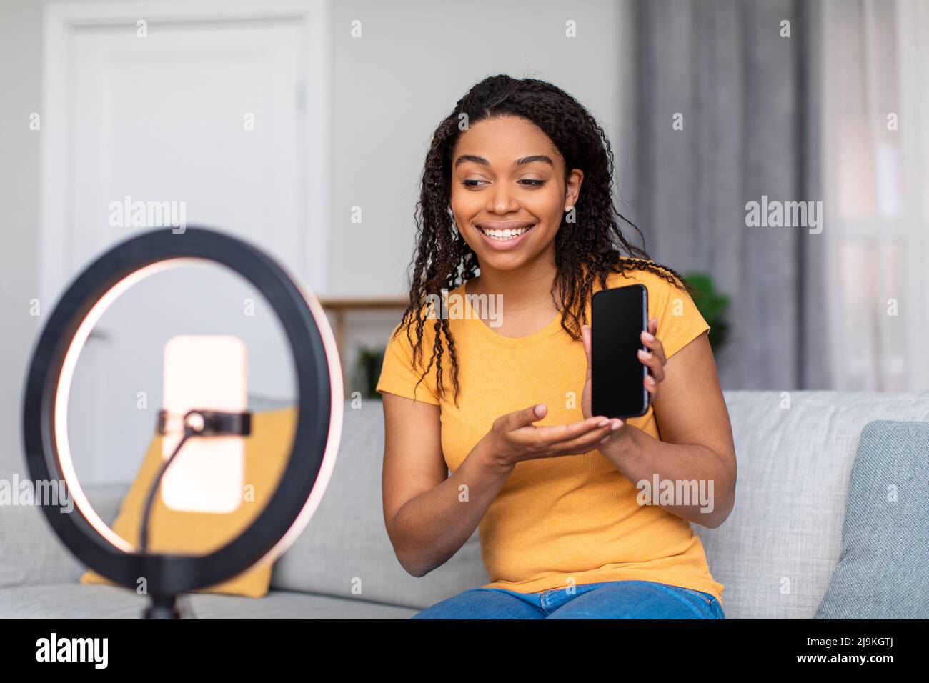 African american female influencer filming video review of modern ...