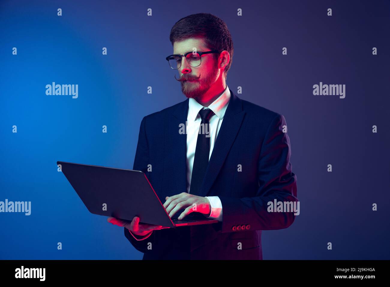 Portrait of young stylish serious man in business suit working remote ...