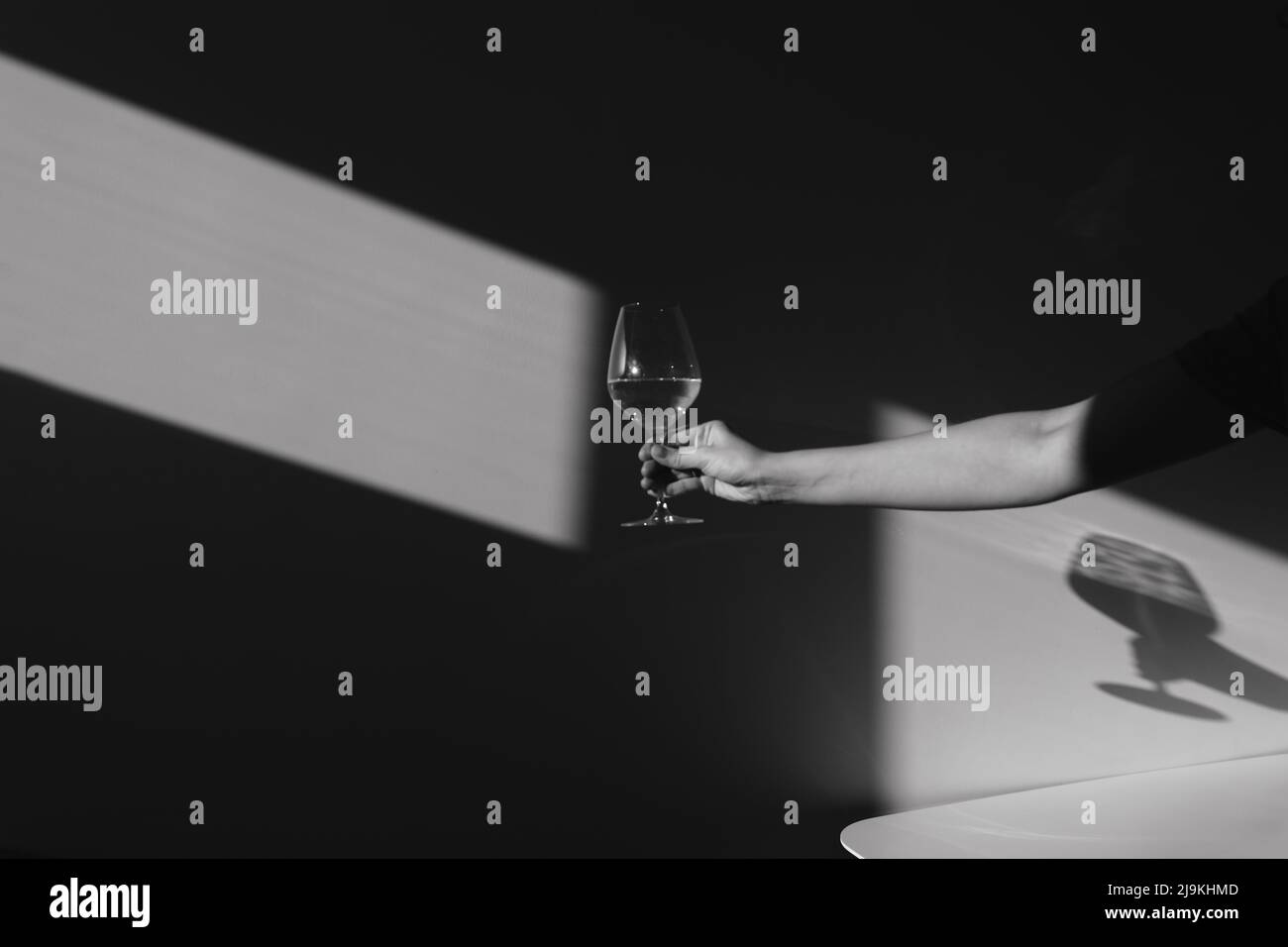 Shadow on the wall of a female sommelier with a glass of wine ...