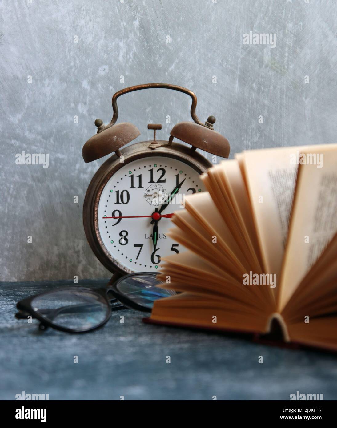 Still life with vintage mechanical alarm clock. Retro objects on grey ...