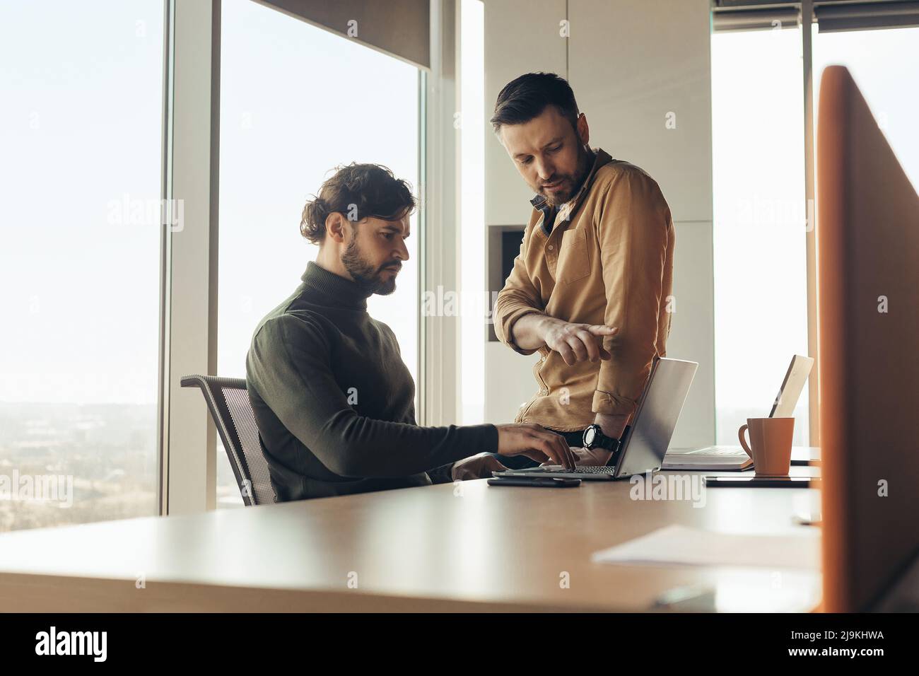 Male coworkers having friendly communication, using laptop pc at ...