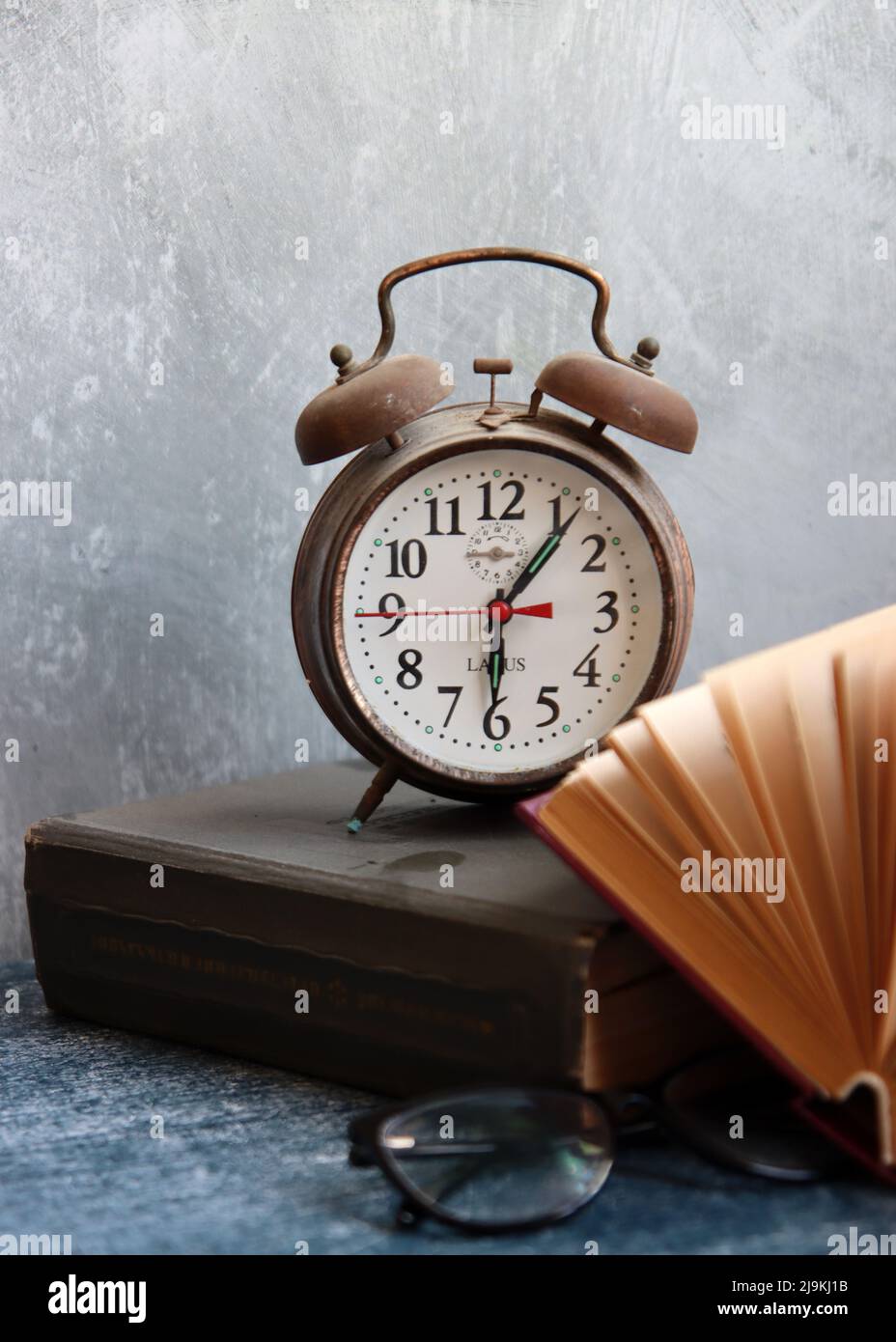 Still life with vintage mechanical alarm clock. Retro objects on grey ...