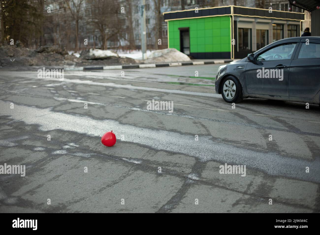 Red ball in city. Ball on road. Object that contrasts with its ...