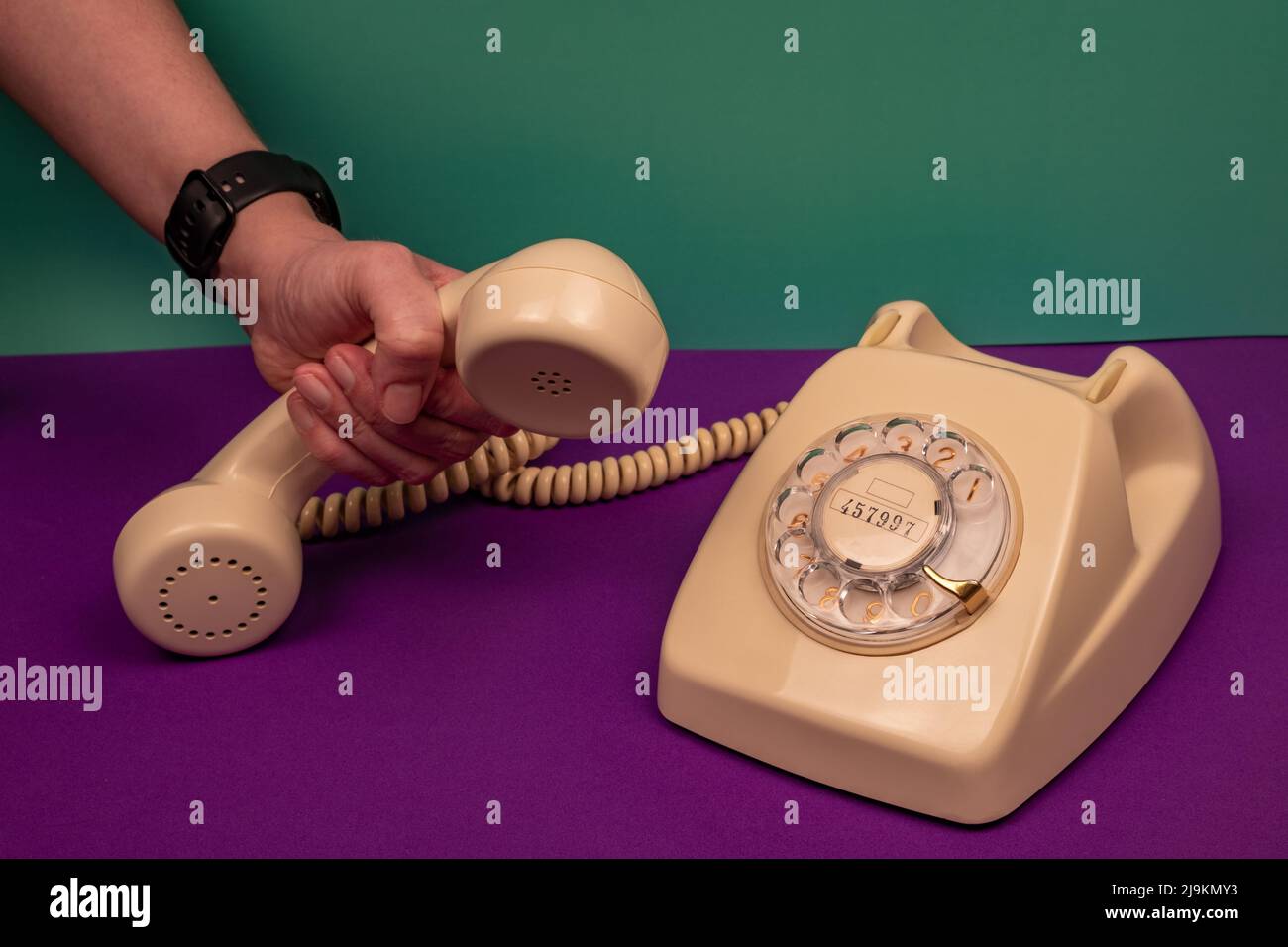 Woman's hand picking up an old phone Stock Photo - Alamy