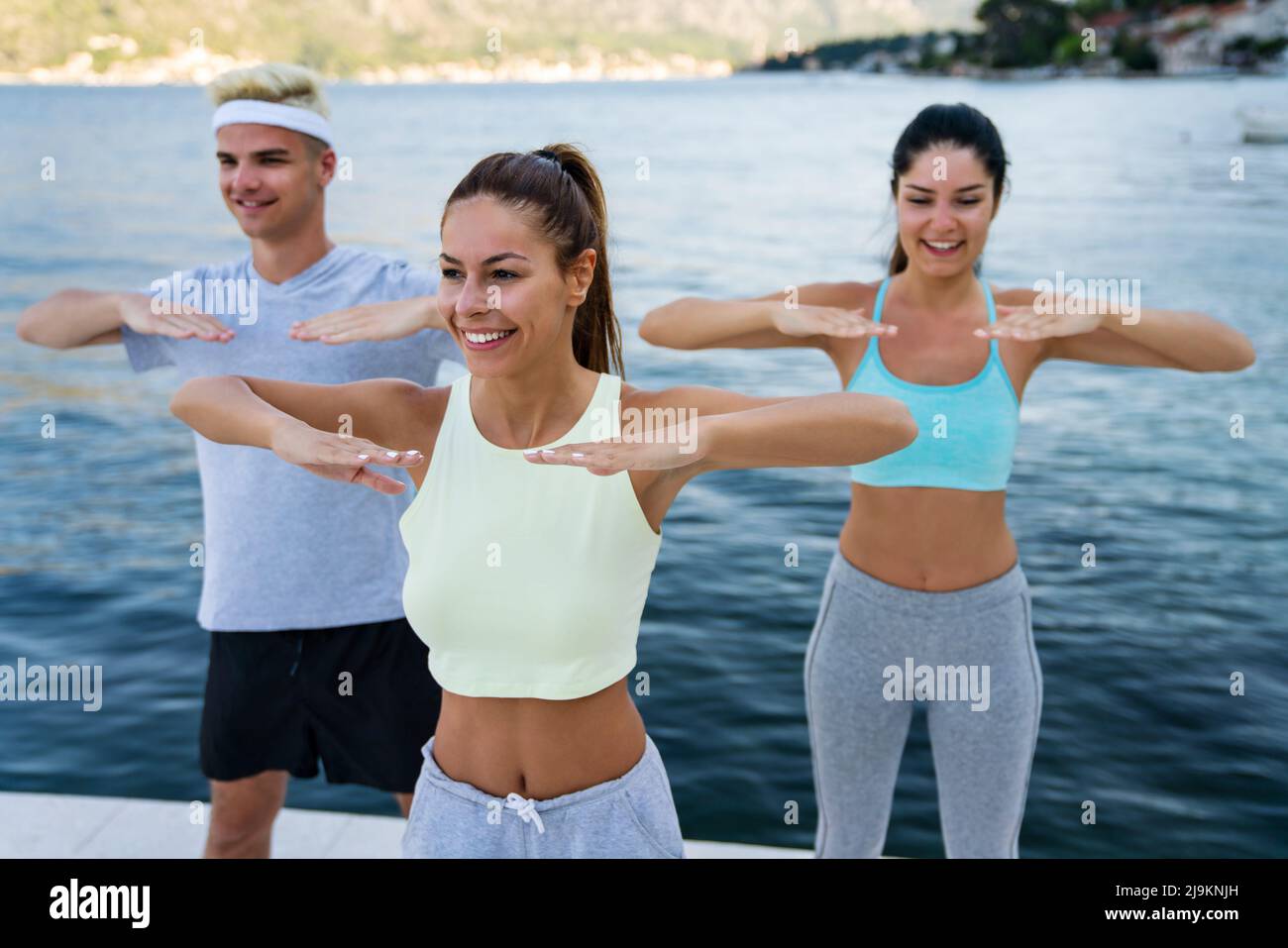 Group of cheerful fit fitness friends team exercising together outdoor ...