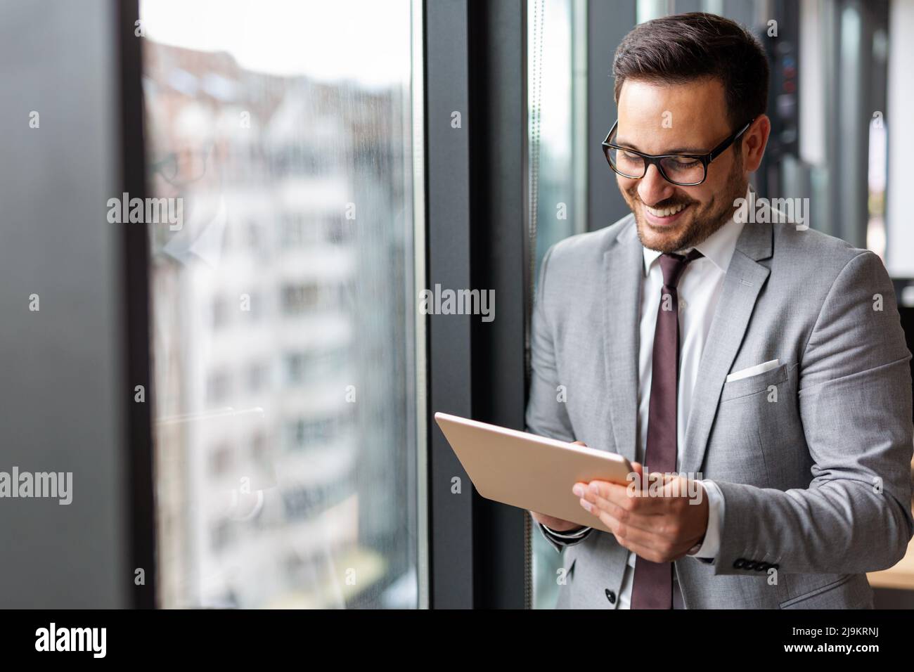 Happy business man manager holding tablet and working in modern office ...