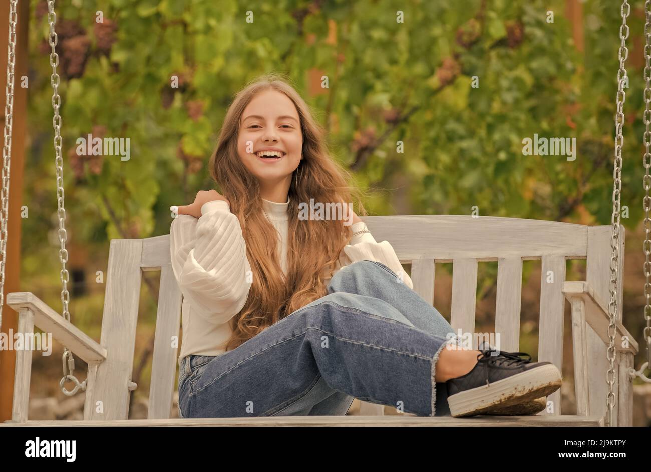 glad teen girl having free time outside on swing, playground Stock ...