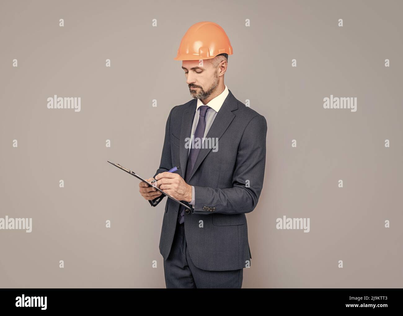 architect man in businesslike suit and hardhat making notes, project ...