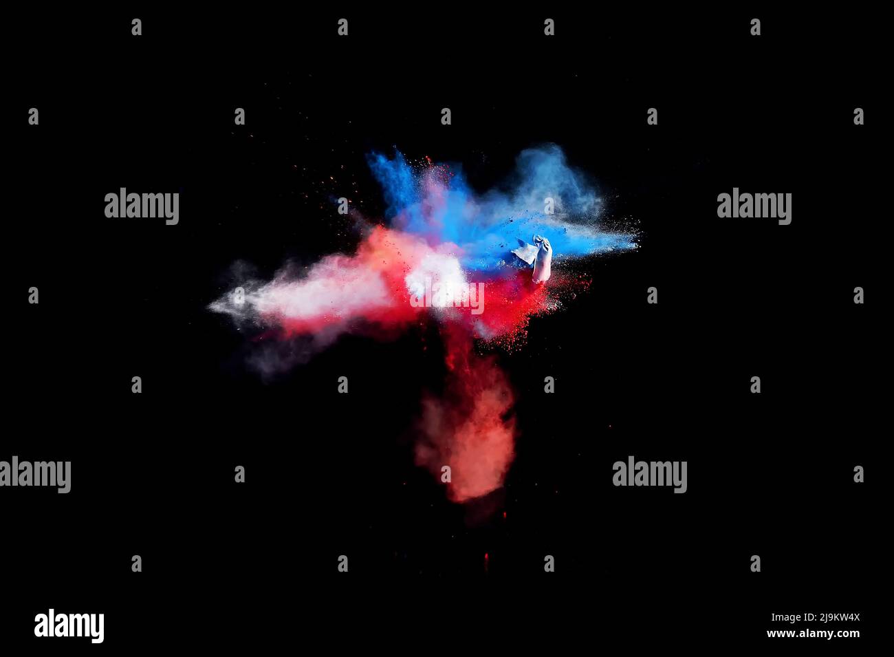 Red, white and blue forms of powder paint combined together explode in ...