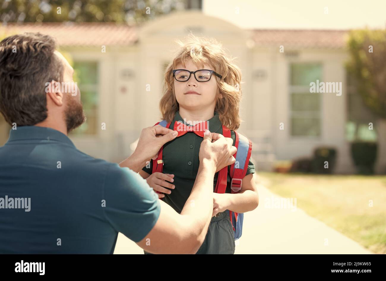 parent gathering little child boy at first grade fix bow tie, school ...