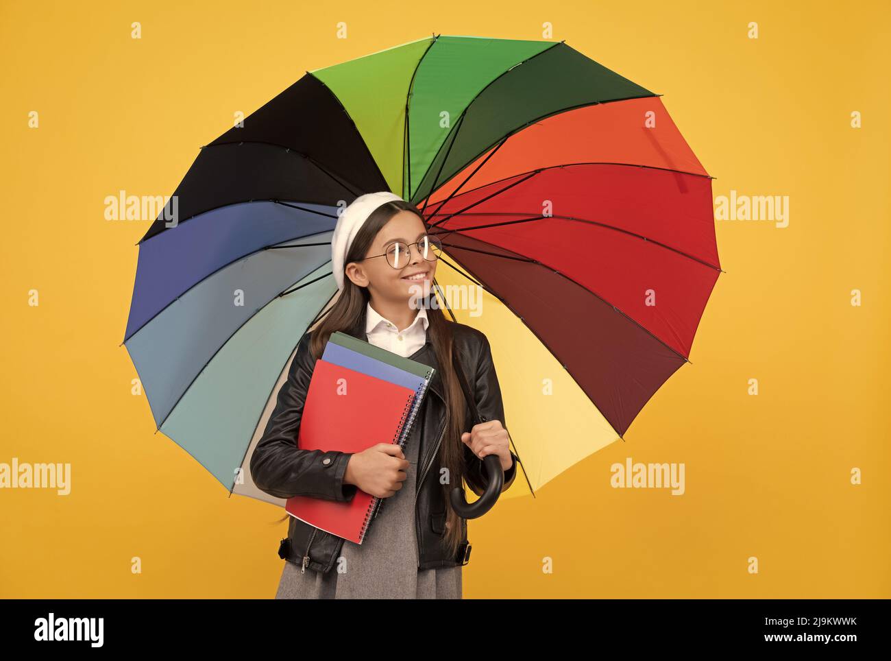 education. teen child under colorful parasol. kid in beret with rainbow ...