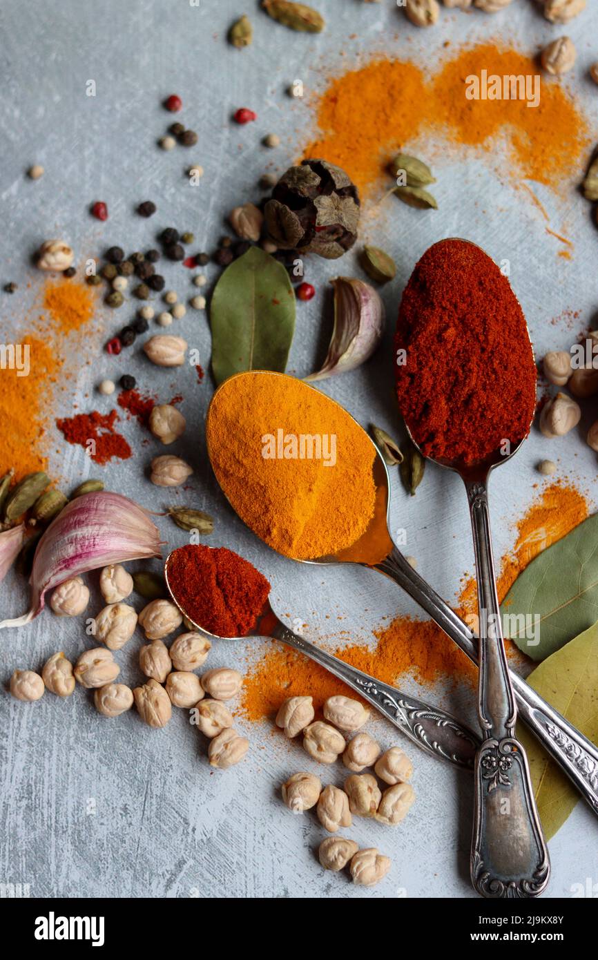 Still life with silver spoons, turmeric , paprika powder, bay leaf and ...