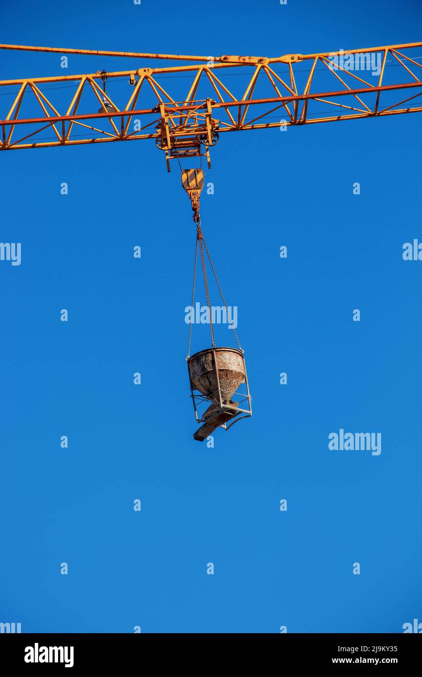 A crane lifts concrete for a modern metal-concrete structure of a ...
