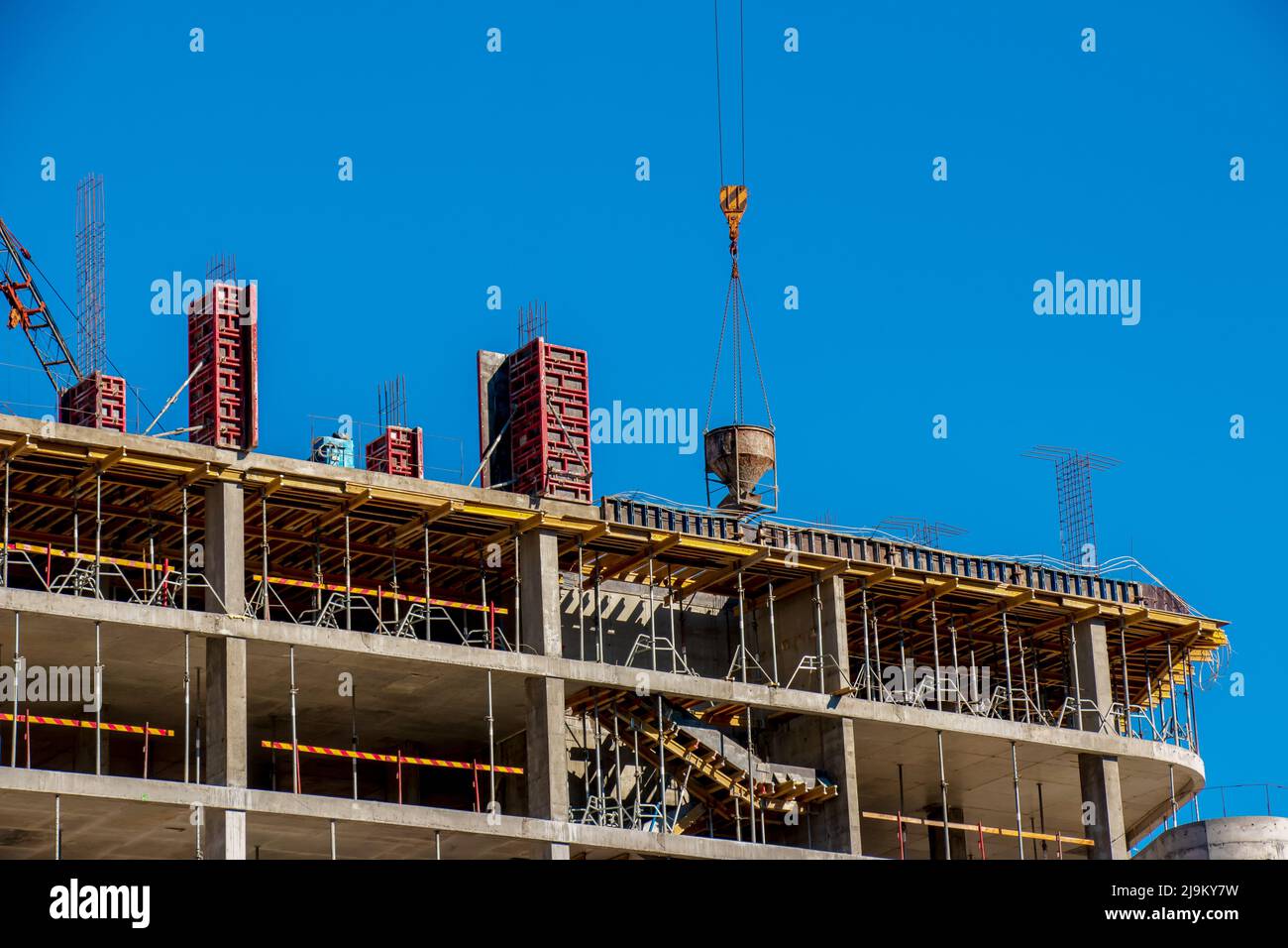 A crane lifts concrete for a modern metal-concrete structure of a ...